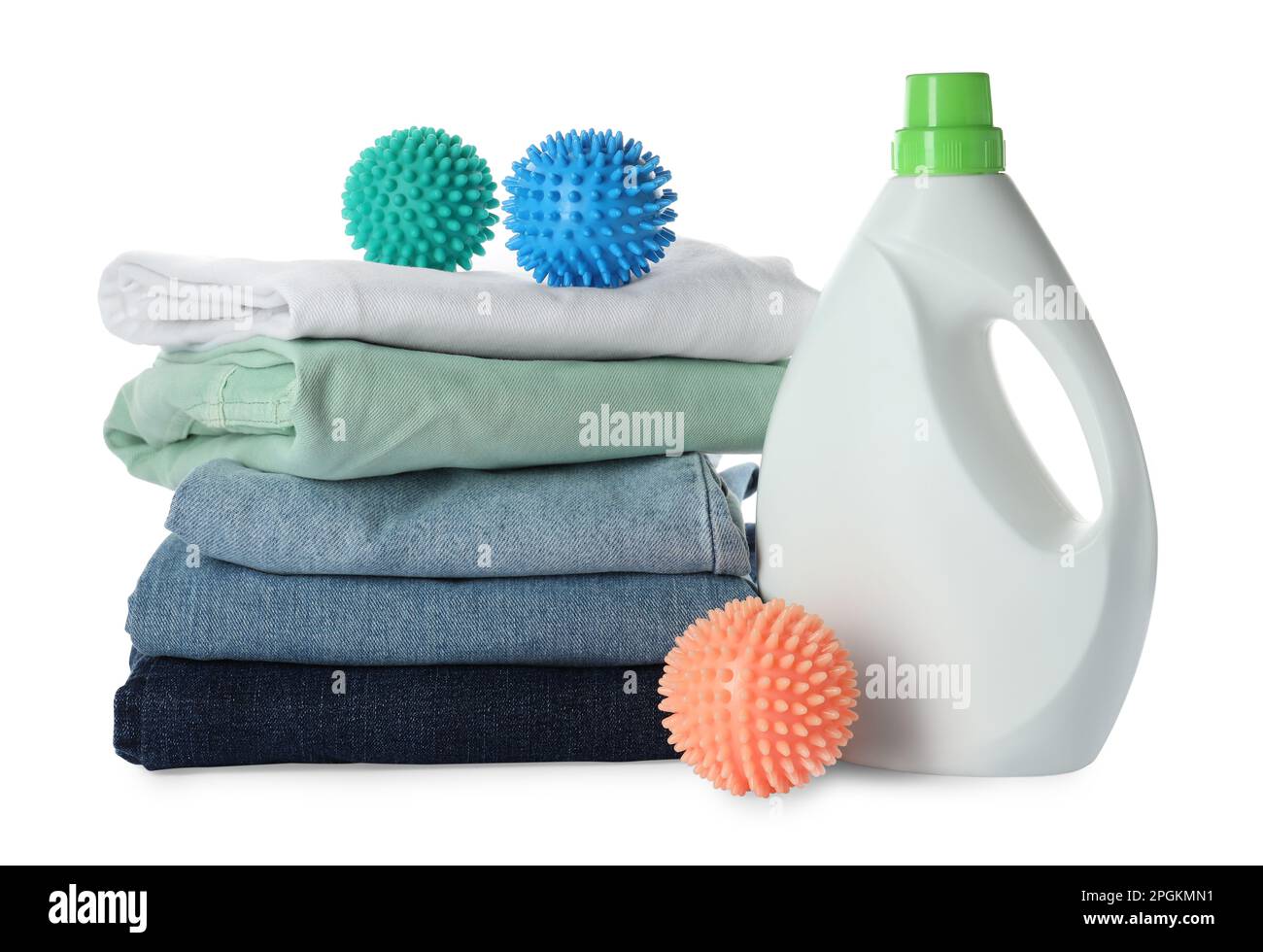 Color dryer balls, laundry detergent and stacked clean clothes on white ...