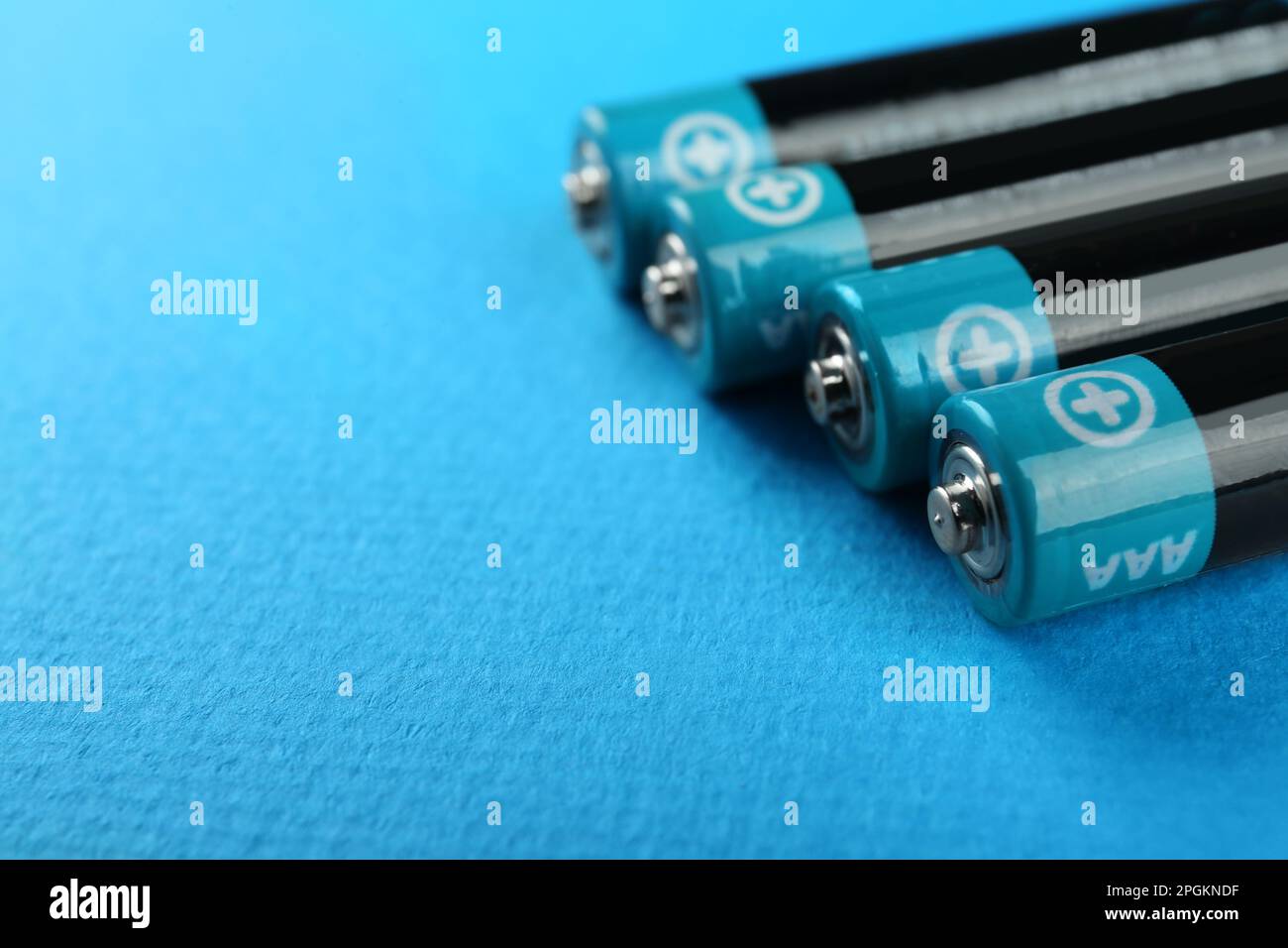 New AAA batteries on tuquoise background, closeup. Space for text Stock ...