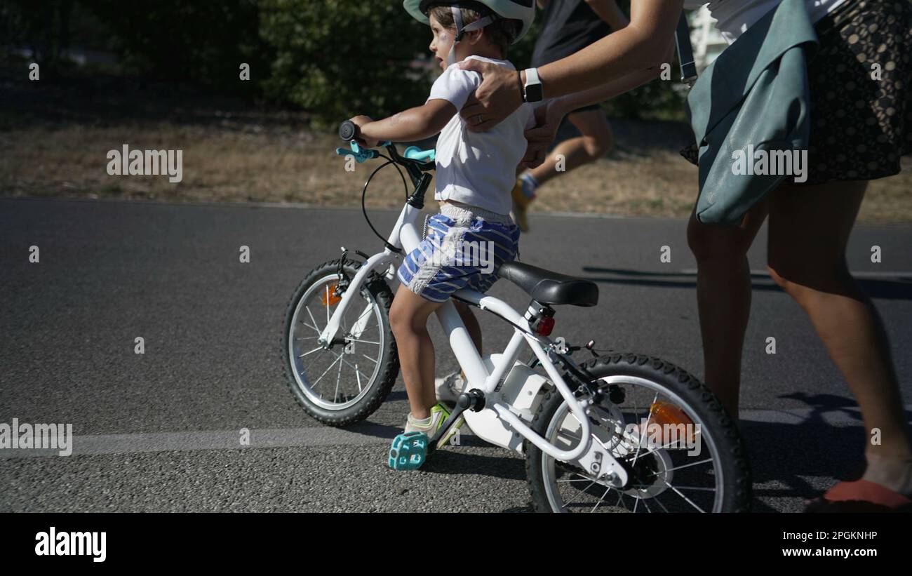 Child falling from bicycle while learning to ride. Small boy falls from ...