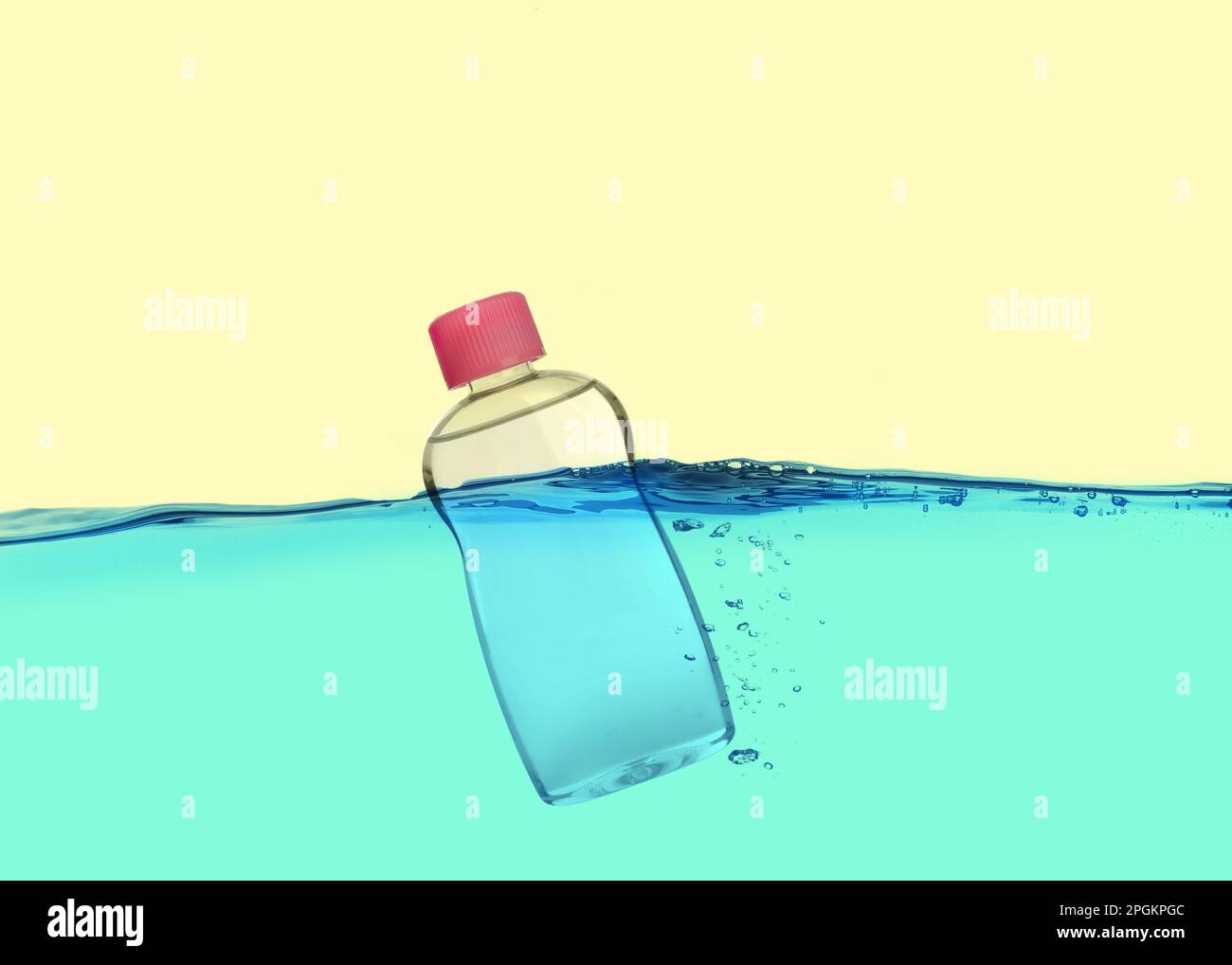 Bottle of baby oil floating in water against beige background Stock ...