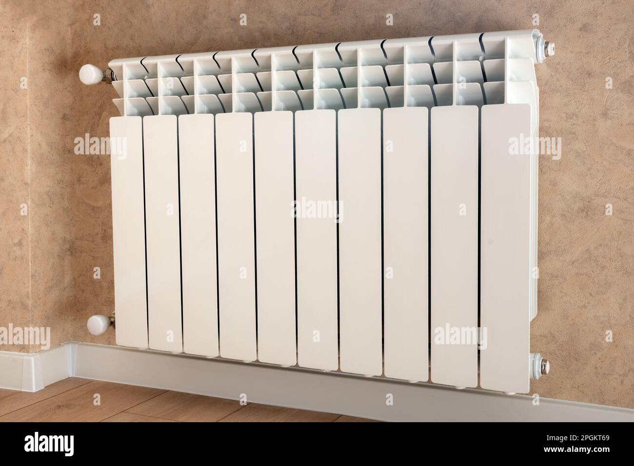 Multisection heating radiator with taps on the wall Stock Photo - Alamy