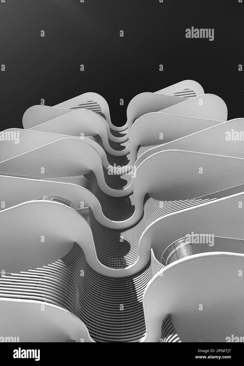 A vertical grayscale shot of a contemporary building with a weird ...