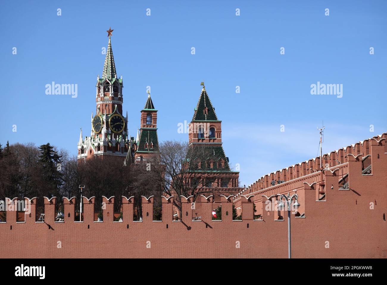Long red brick Kremlin wall with towers with spires and stars under ...