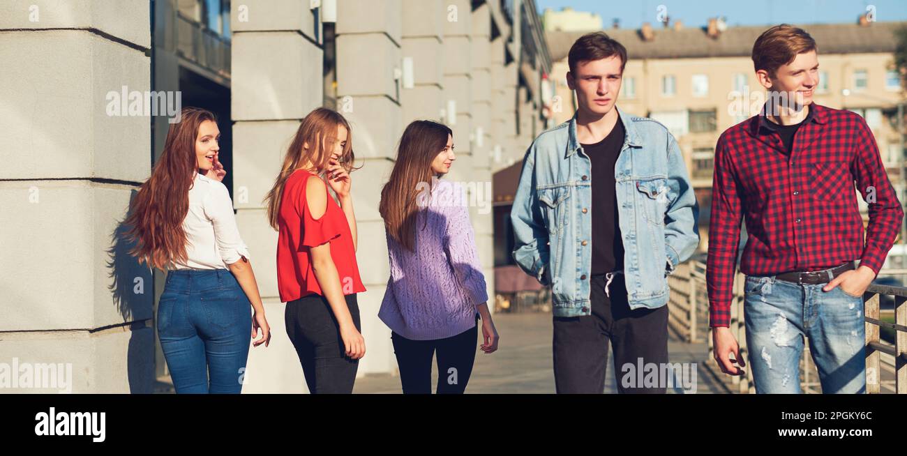 Group of young woman flirting with men in city Stock Photo - Alamy