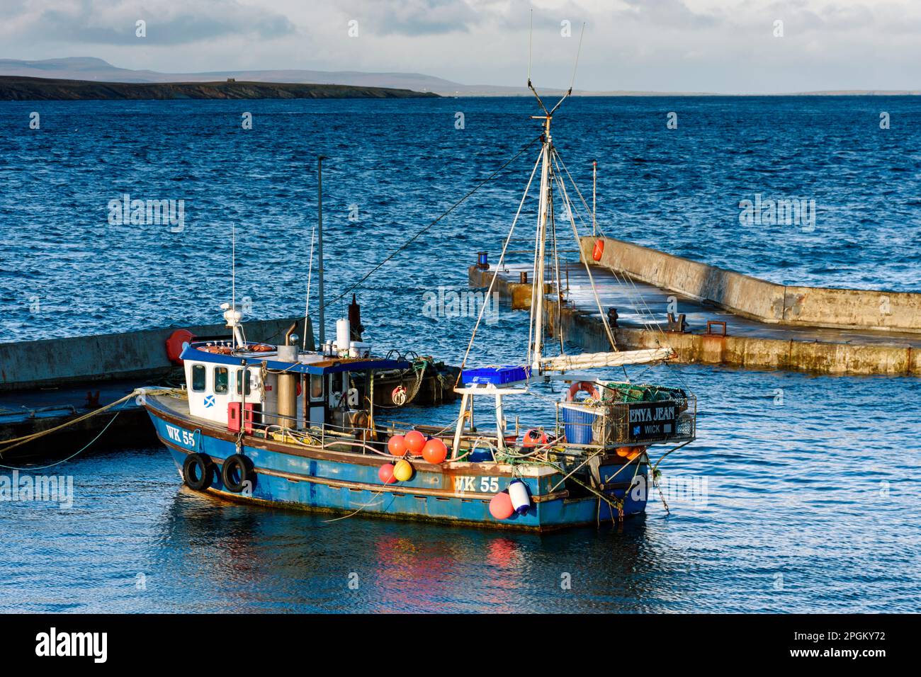 A fishing boat in John o' Groats harbour at high tide, Caithness ...