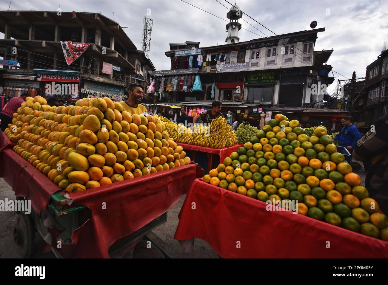 Srinagar, India. 23rd Mar, 2023. A roadside vendor selling fruits to ...