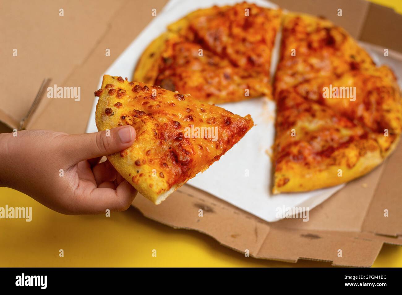 hand taking a slice of pizza from a cardboard pizza box Stock Photo - Alamy