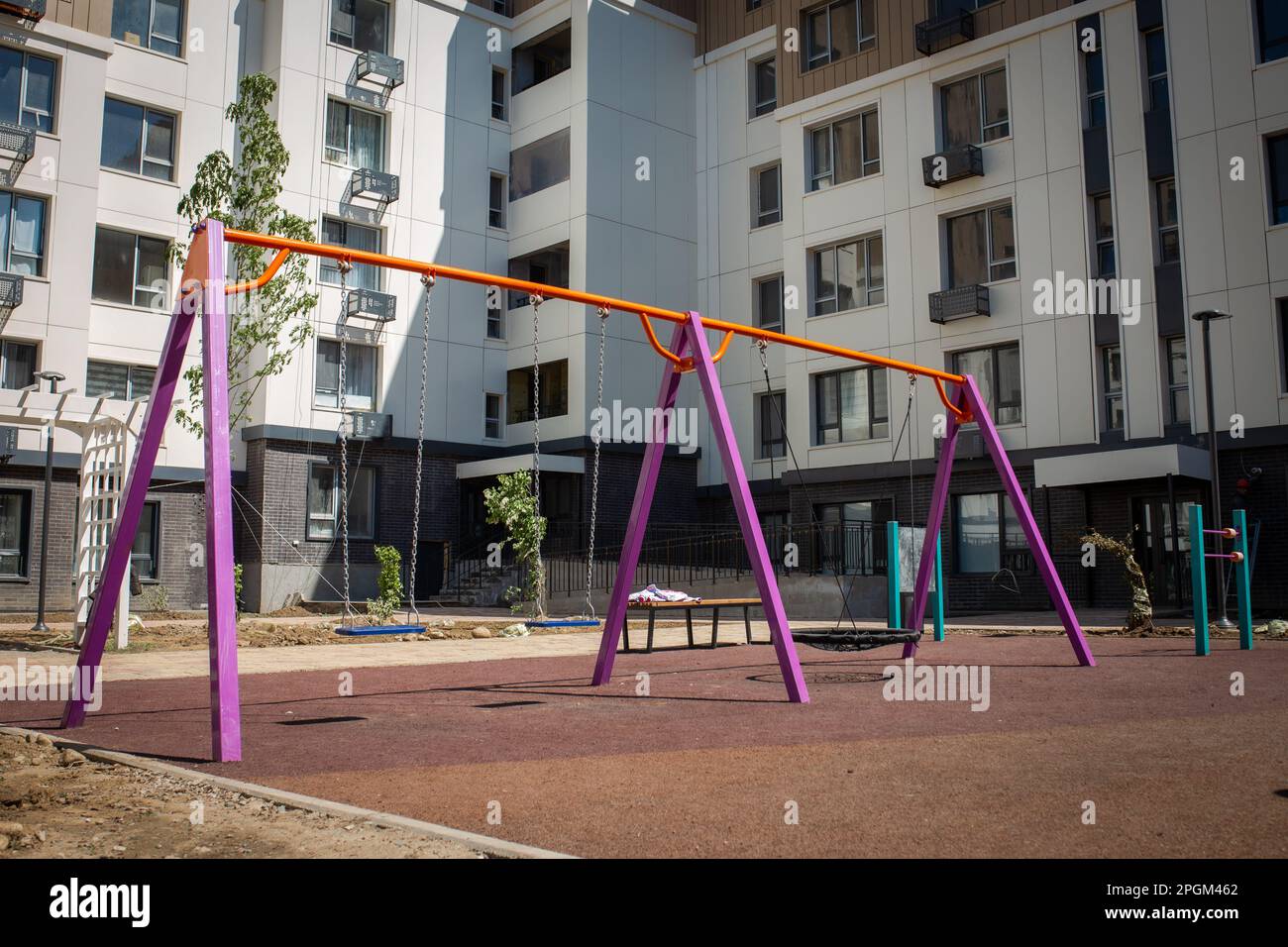 A new colorful playground in a sunny summer courtyard among residential ...