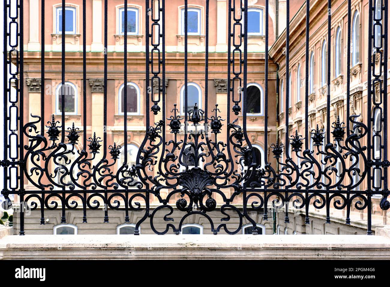 black wrought iron fence above beige stone base and sill. forged steel ...