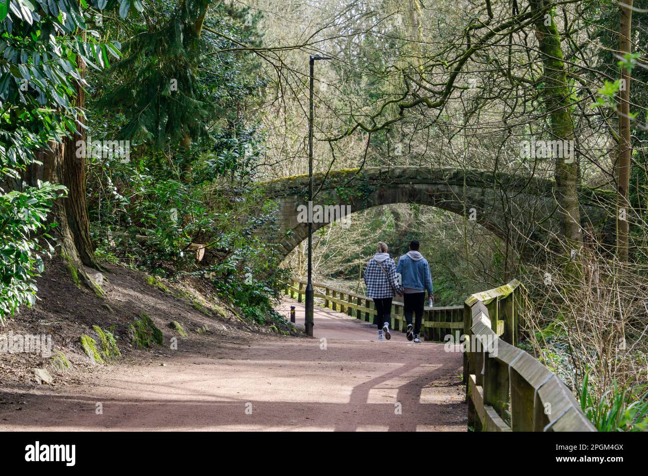 A couple walk under a bridge in the tranquility of Jesmond Dene, the ...