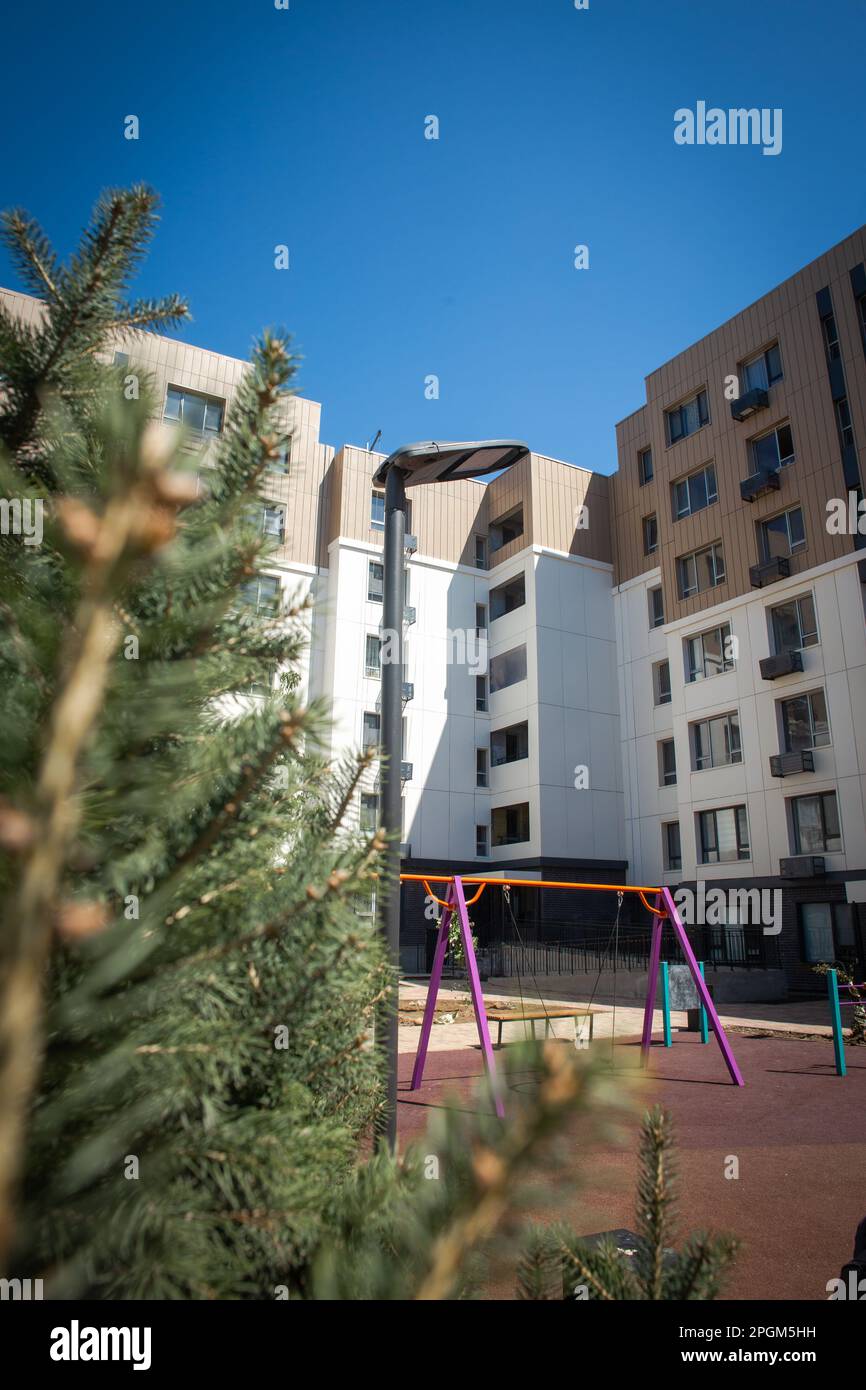 A new colorful playground in a sunny summer courtyard among residential ...