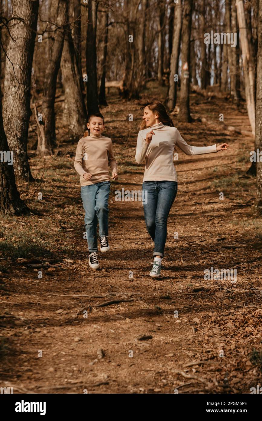 Happy Mother and Child Running on Path in Forest Stock Photo - Alamy