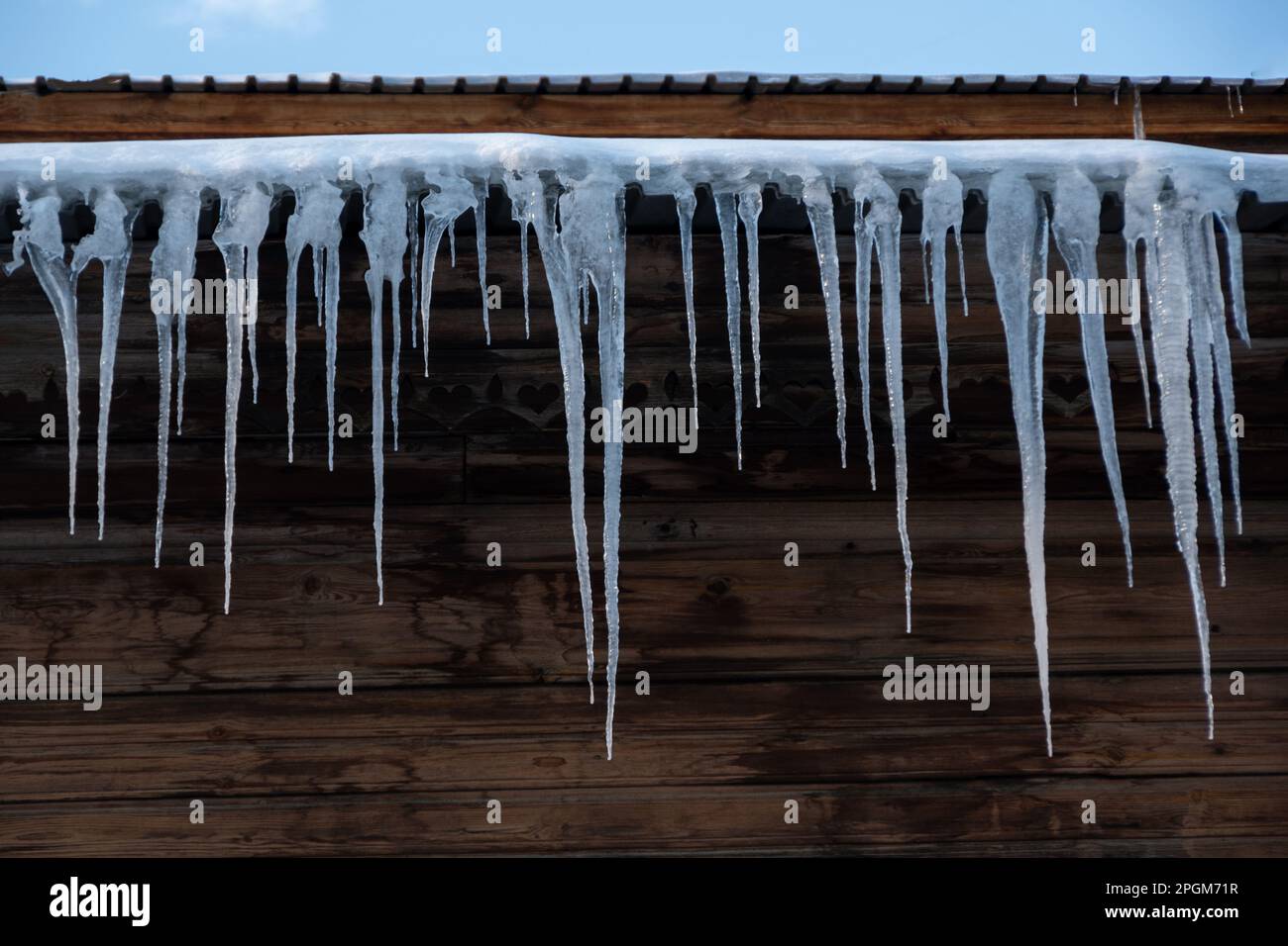 Beautiful huge icicles hang from the roof of the building. Melting ...