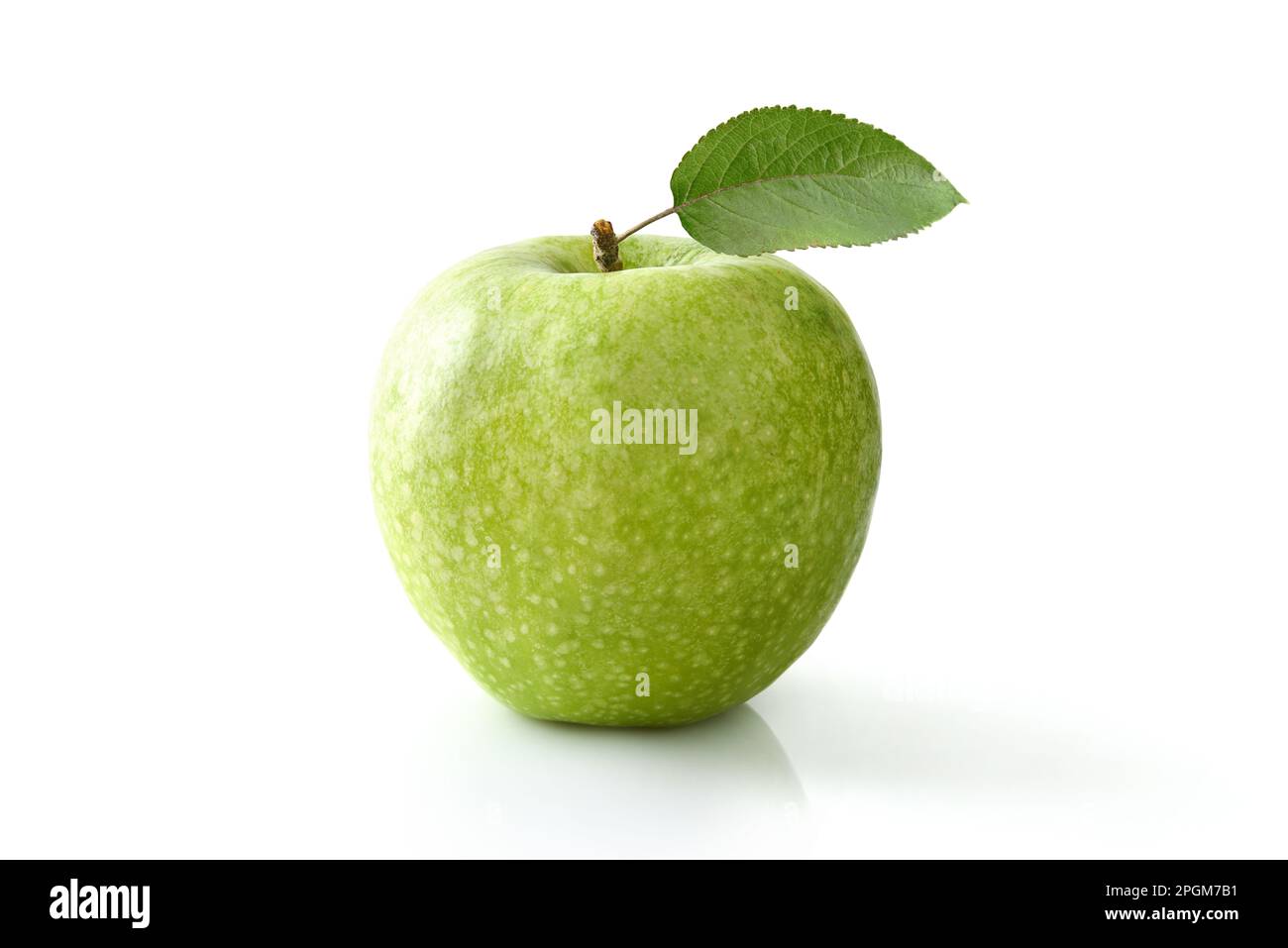 Green apple with stem and leaf, reflected on white table and white ...