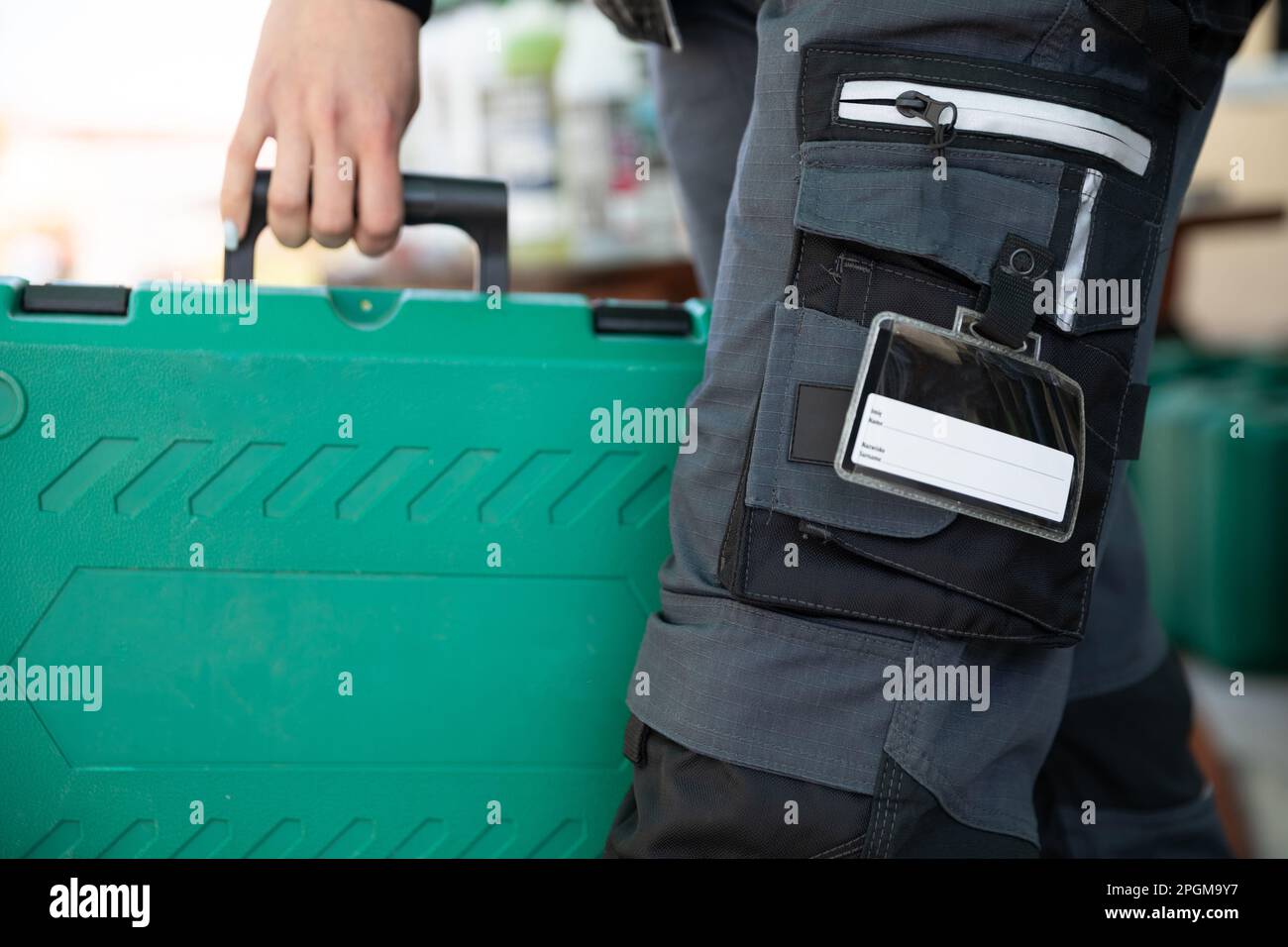 A girl in work pants holds a green tool case in her hand Stock Photo ...