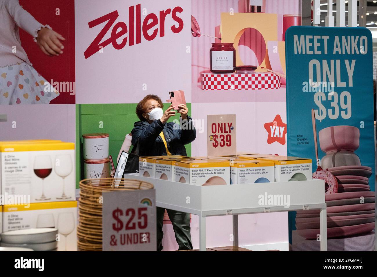 A shopper takes a selfie with a Zellers sign in a newly-opened Zellers ...