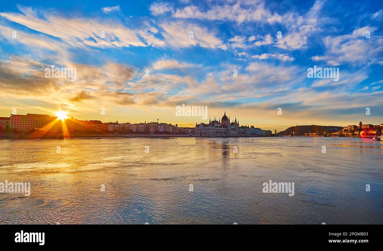 The bright sunrise sky with orange and purple clouds over Danube River ...