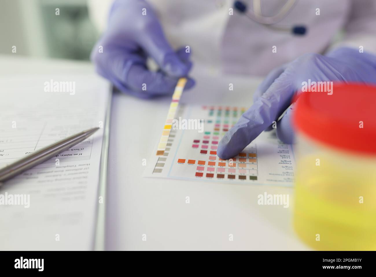 Worker checks results of urine test looking at color palette Stock ...