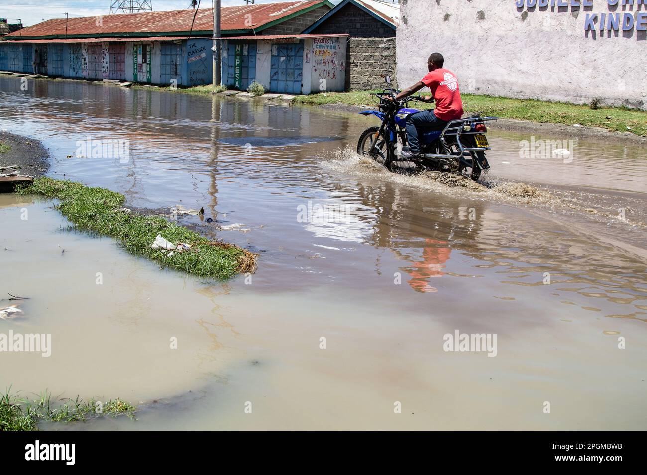 A motorcyclist navigates through a flooded road in Nakuru, following ...