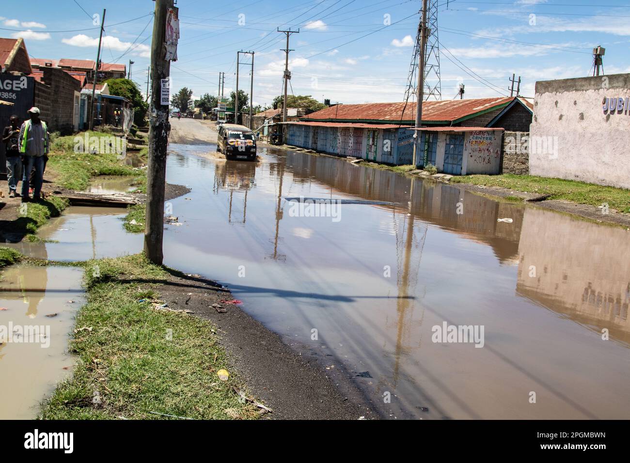 A car drives through a flooded road in Nakuru, following heavy rainfall ...
