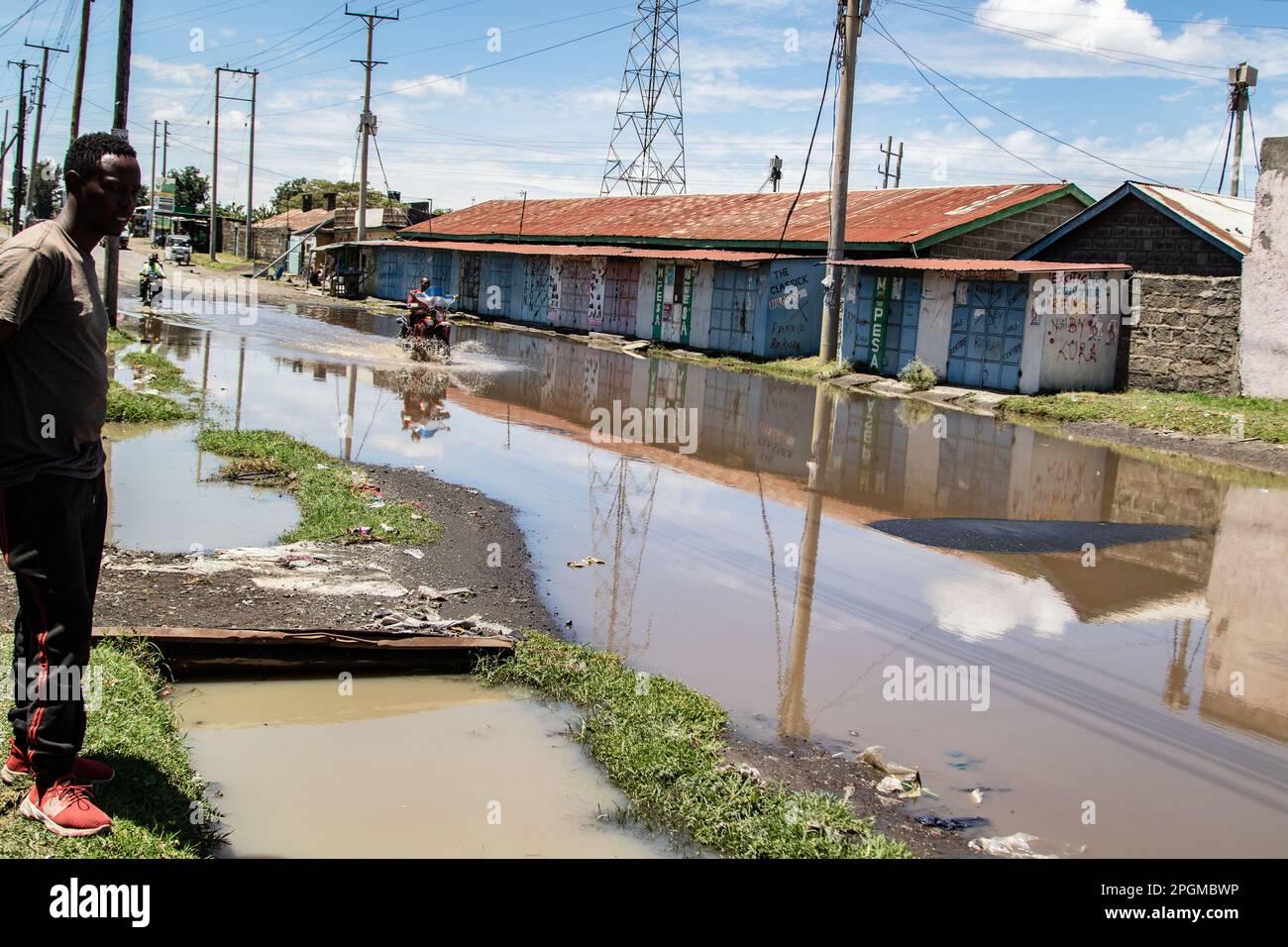 Motorcyclists navigate through a flooded road in Nakuru, following ...