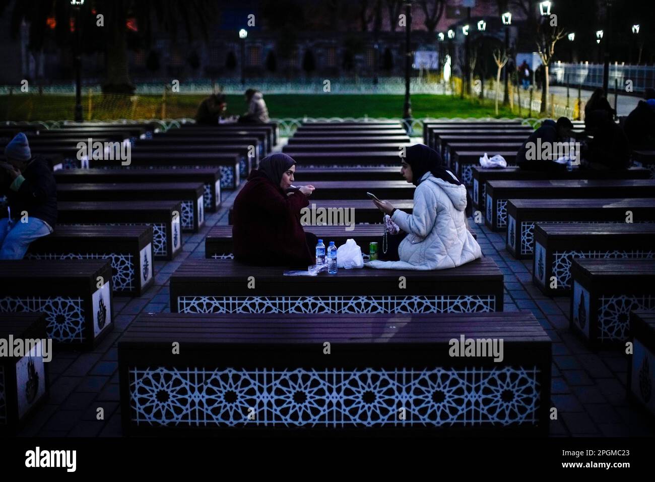 People break their fast after dusk on the first day of Ramadan next to ...