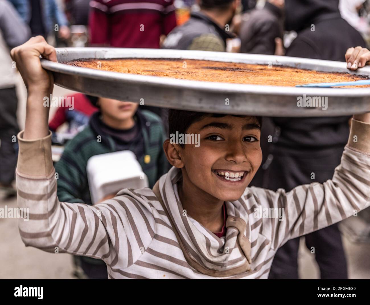 Ariha, Syria. 23rd Mar, 2023. A young Syrian vendor strolls with ...