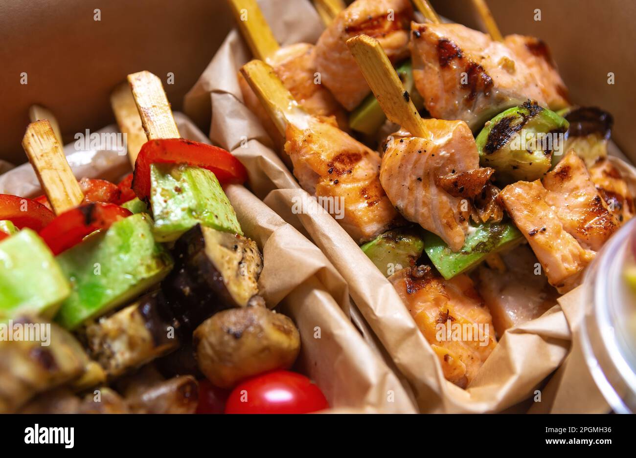 Grilled salmon fish fillet and vegetables cooked on skewers and ...