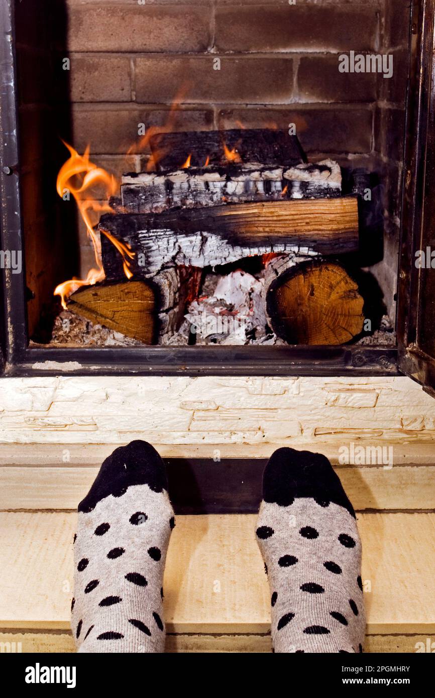 to warm one's feet by the fire Stock Photo - Alamy