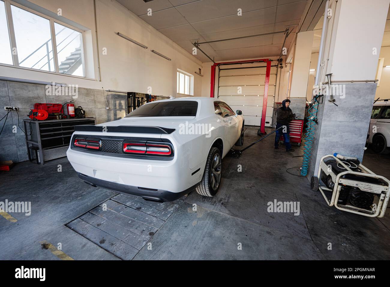 Mechanic in service repair station working with muscle car. Man worker ...
