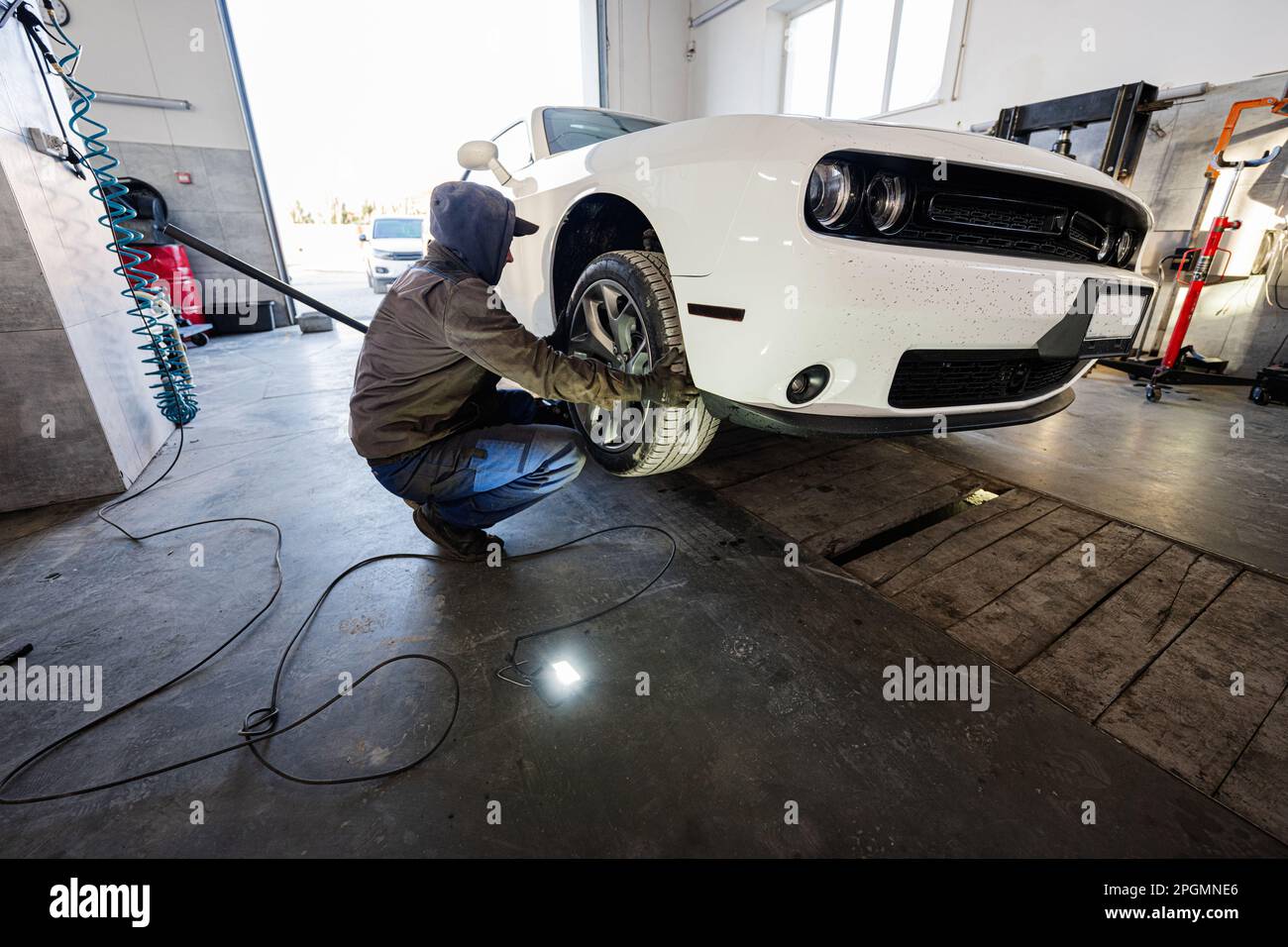 Mechanic in service repair station working with muscle car. Man worker ...