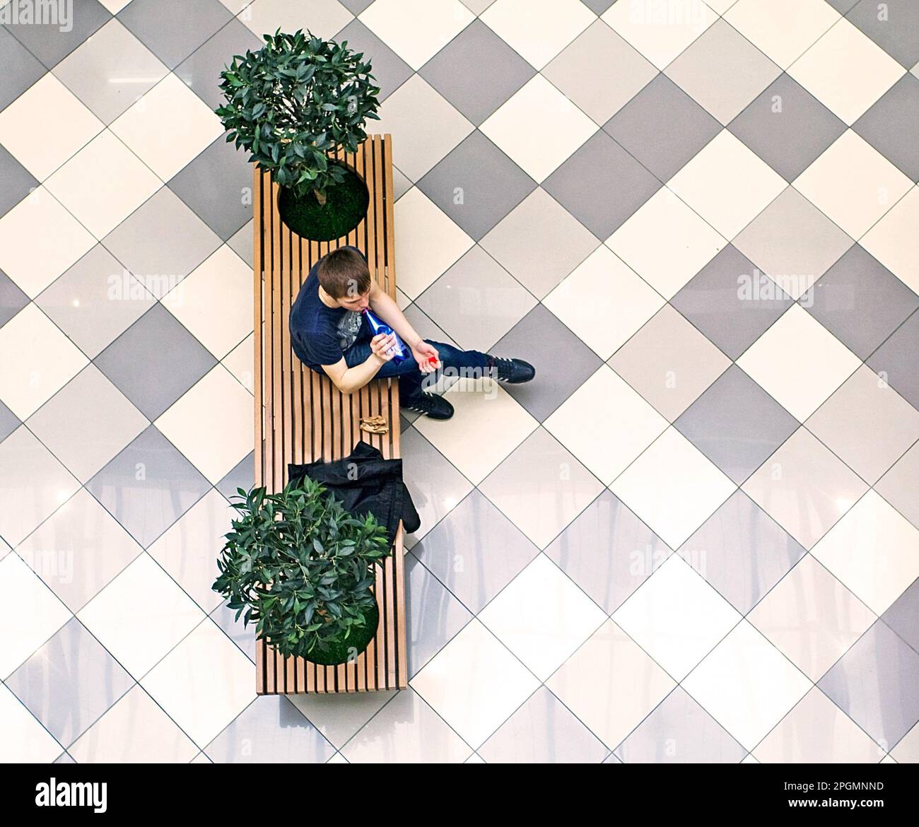 young man biting sitting on the benches, a top view from the ...