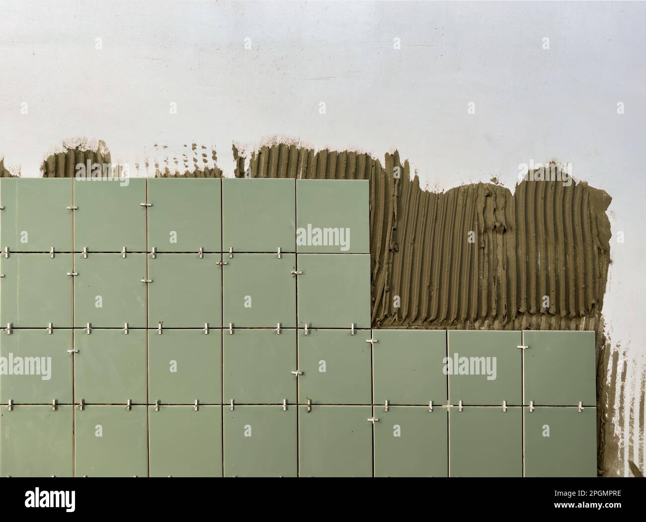 Construction background. Tile adhesive is applied to the wall for ...