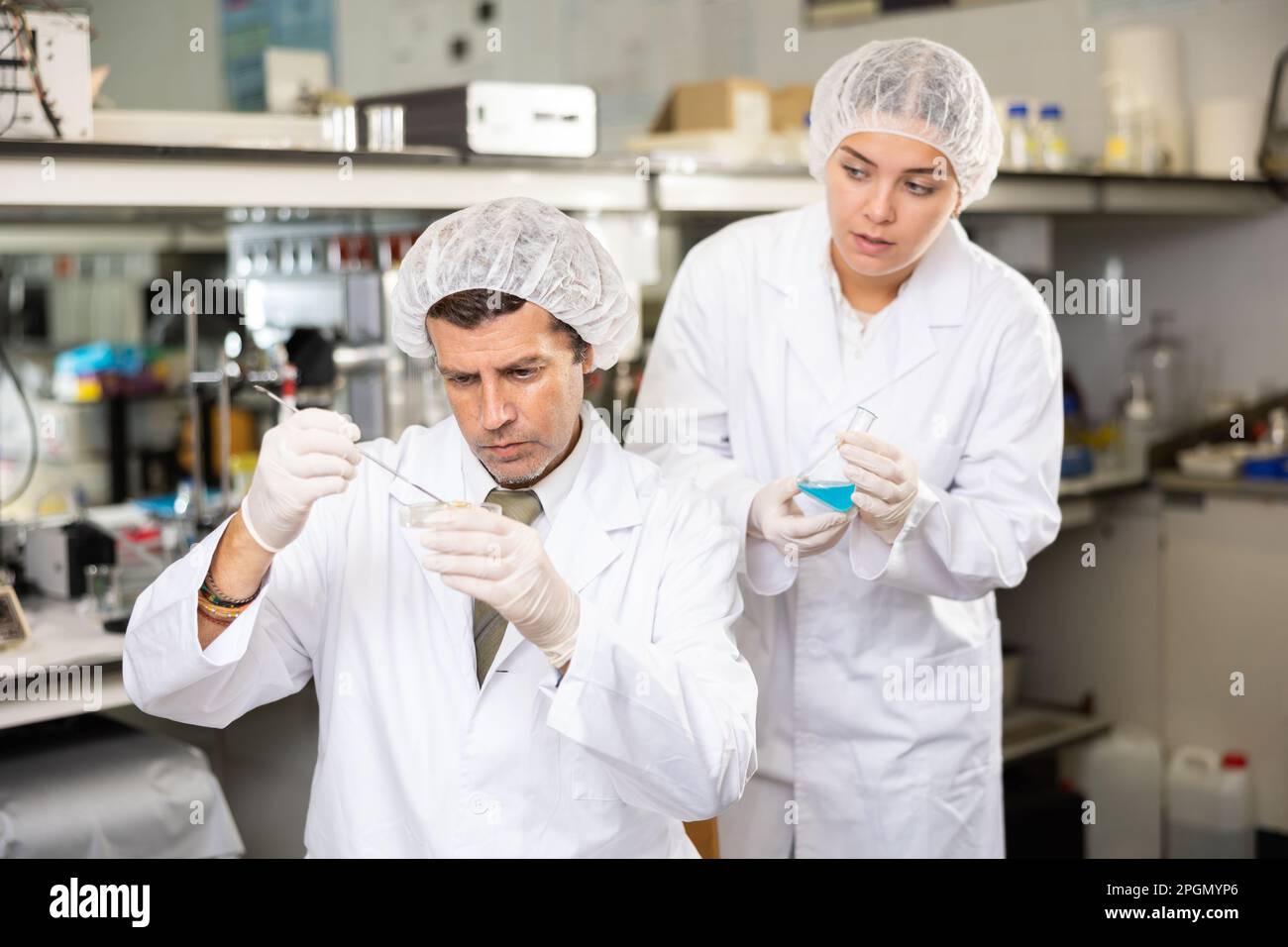 Group of scientists using lab equipment during research in chemical ...