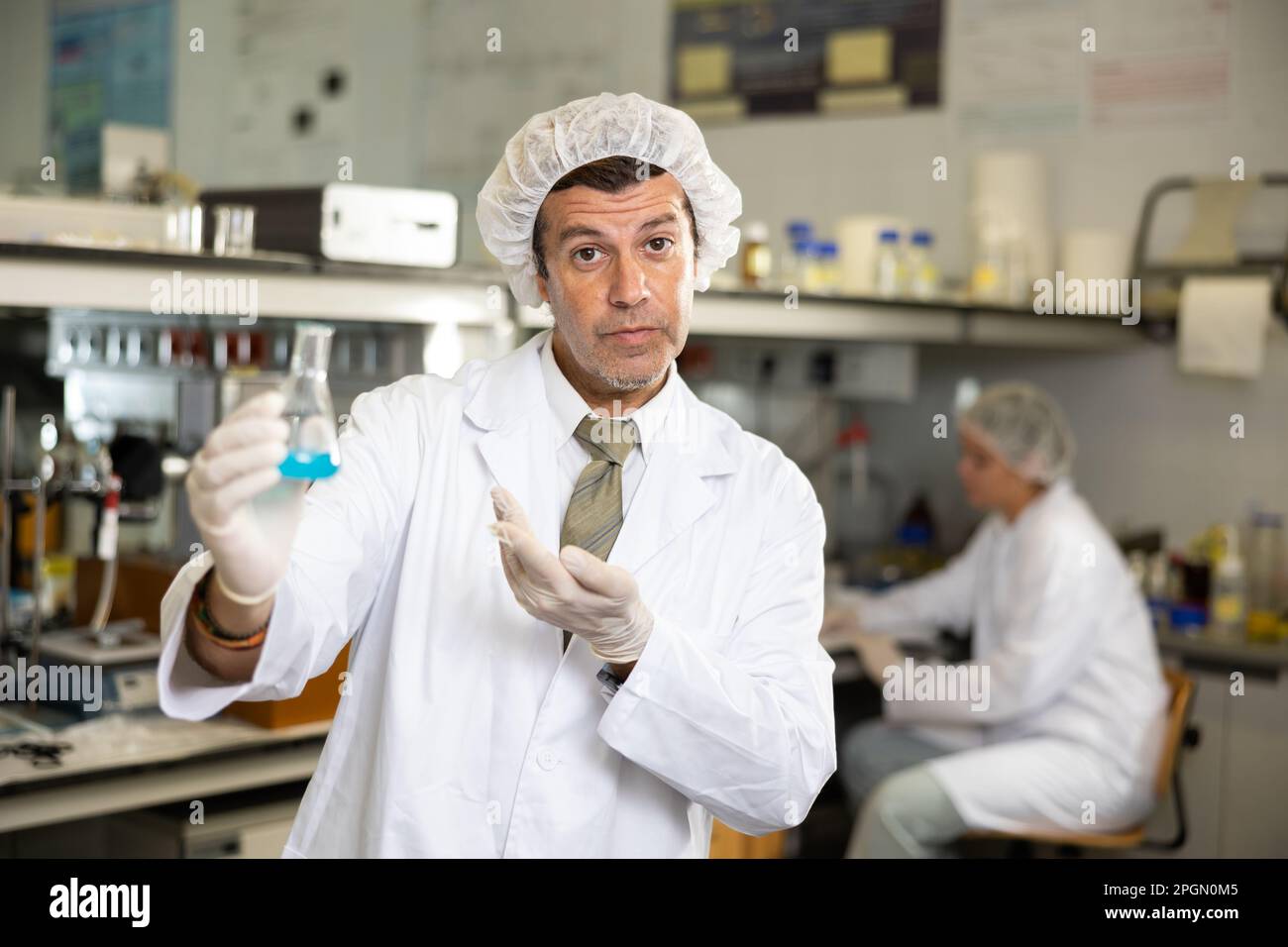 Lab technician working with reagents in test tubes during chemical ...