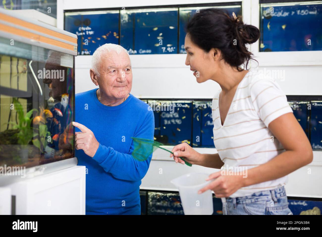 Old man choosing fish in pet shop Stock Photo - Alamy