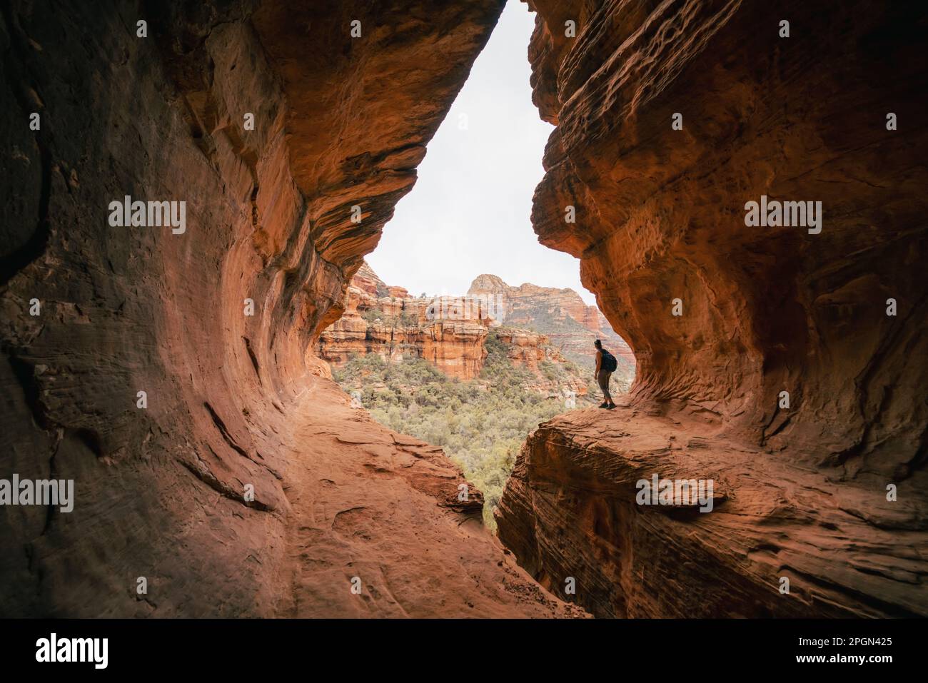 Young 30s woman steps out onto ledge in Subway Cave Boynton Canyon Az ...