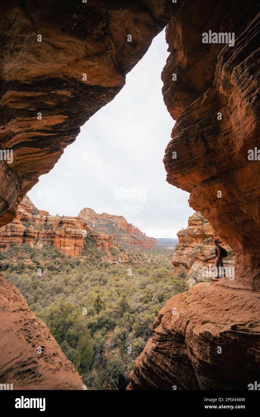 Young 30s woman steps out onto ledge in Subway Cave Boynton Canyon Az ...