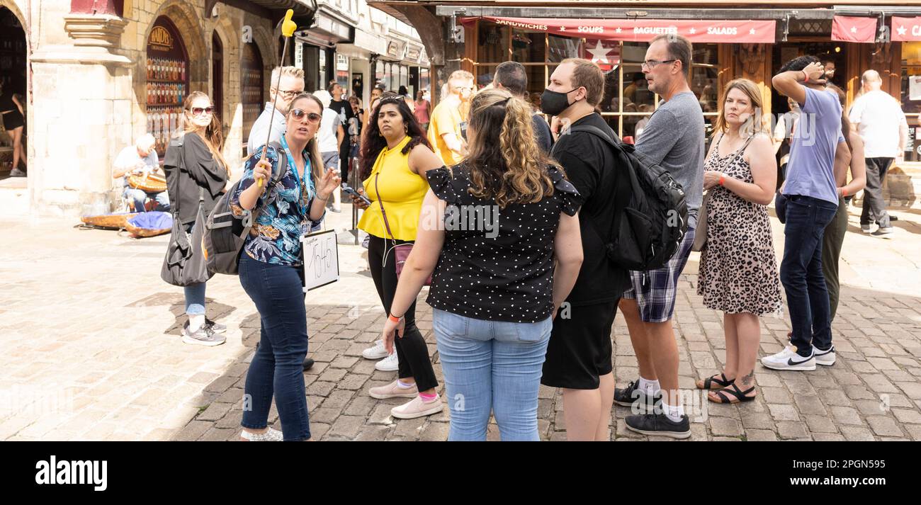 Tour guide holding up a coloured sign leading a tour party of foreign ...
