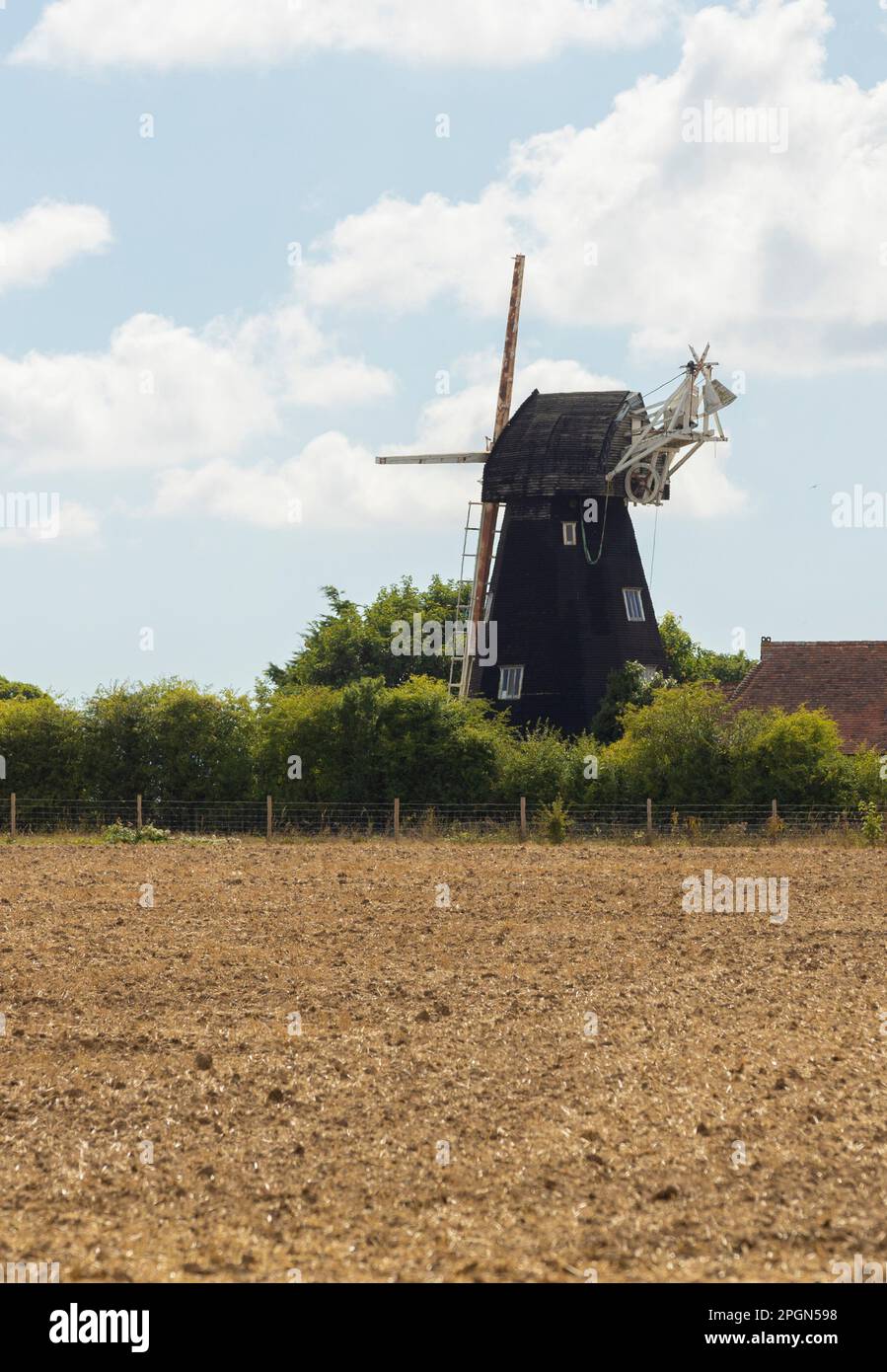 A traditional old English windmill and farm house cottage nestling in ...