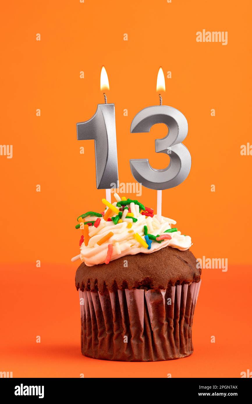 Candle number 13 - Cake birthday in orange background Stock Photo - Alamy