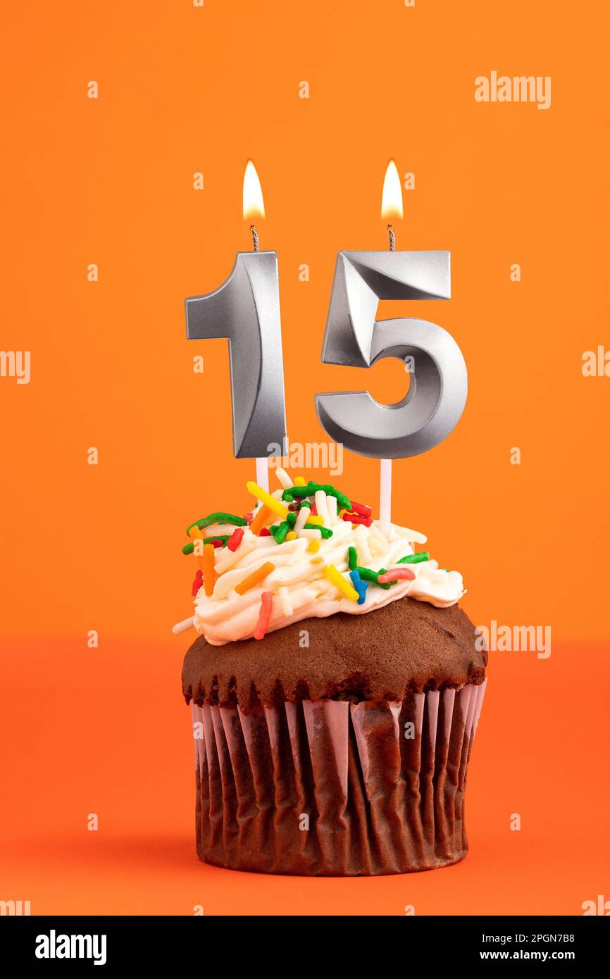 Candle number 15 - Cake birthday in orange background Stock Photo - Alamy