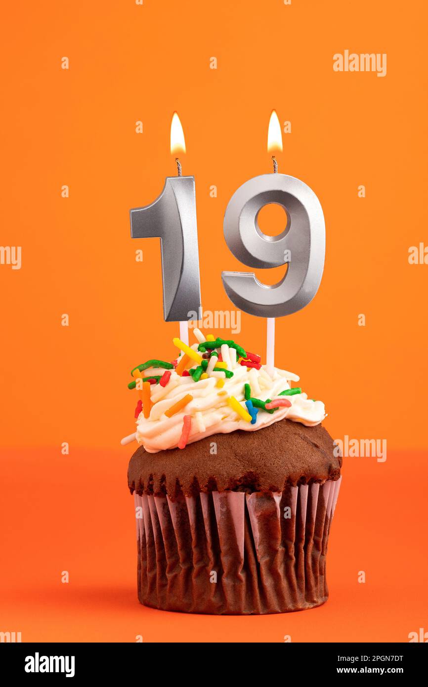Candle number 19 - Cake birthday in orange background Stock Photo - Alamy