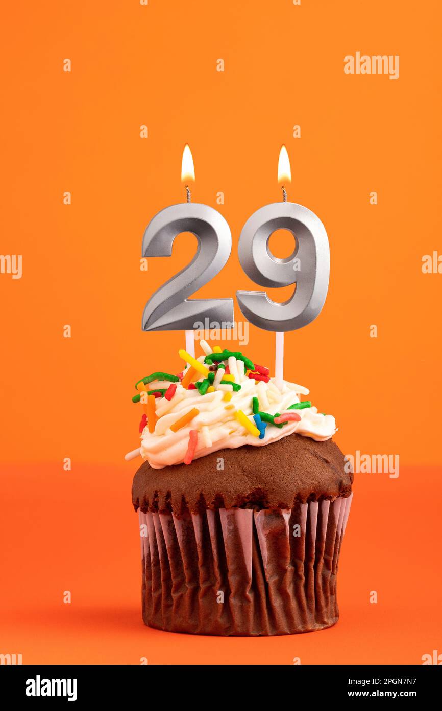 Candle number 29 - Cake birthday in orange background Stock Photo - Alamy