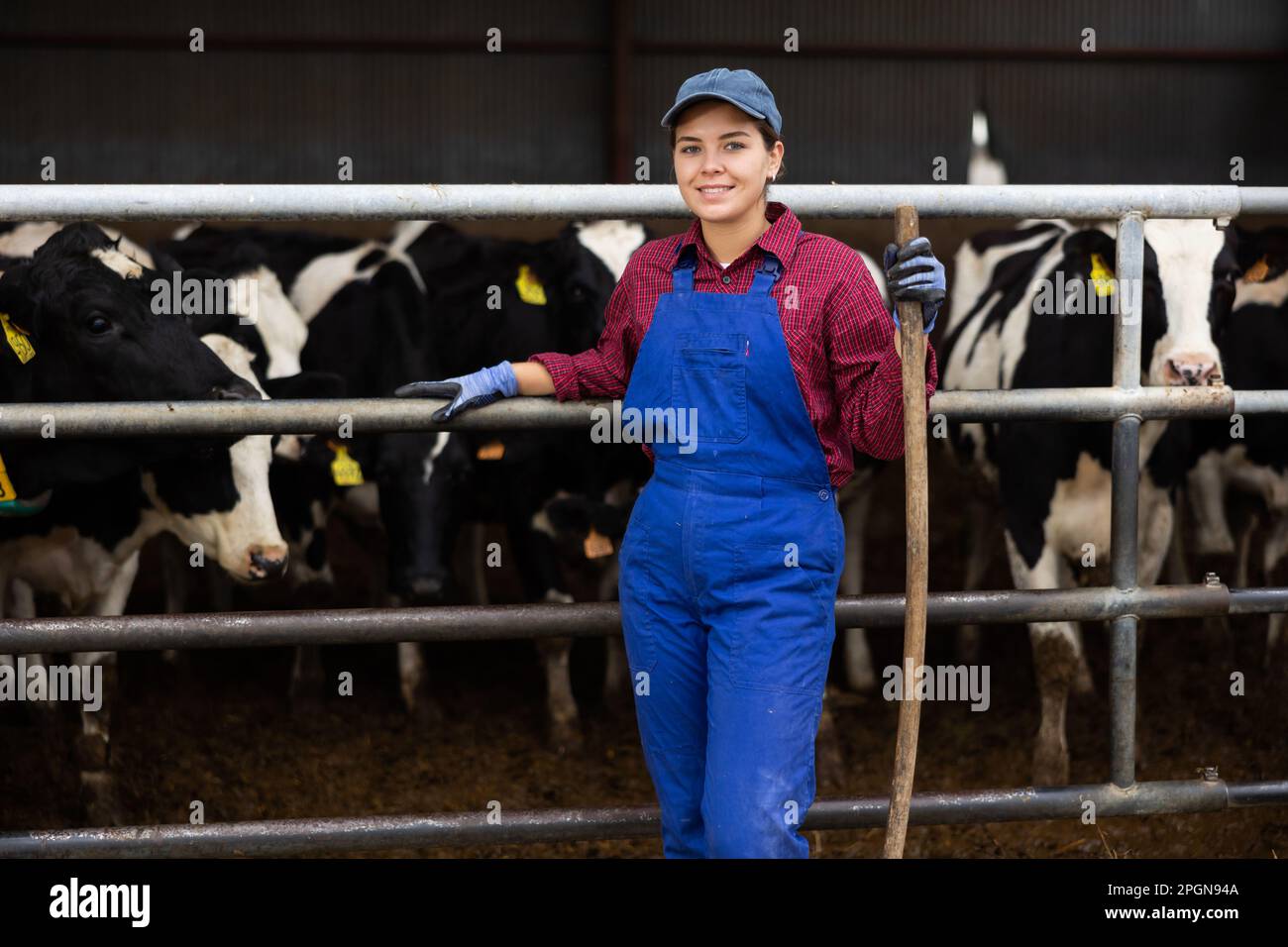 Portrait of smiling European female farmer in uniform with rake during ...