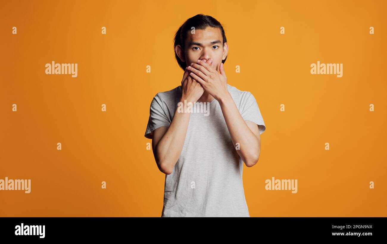 Confident hipster guy doing three wise monkeys sign on camera, using ...