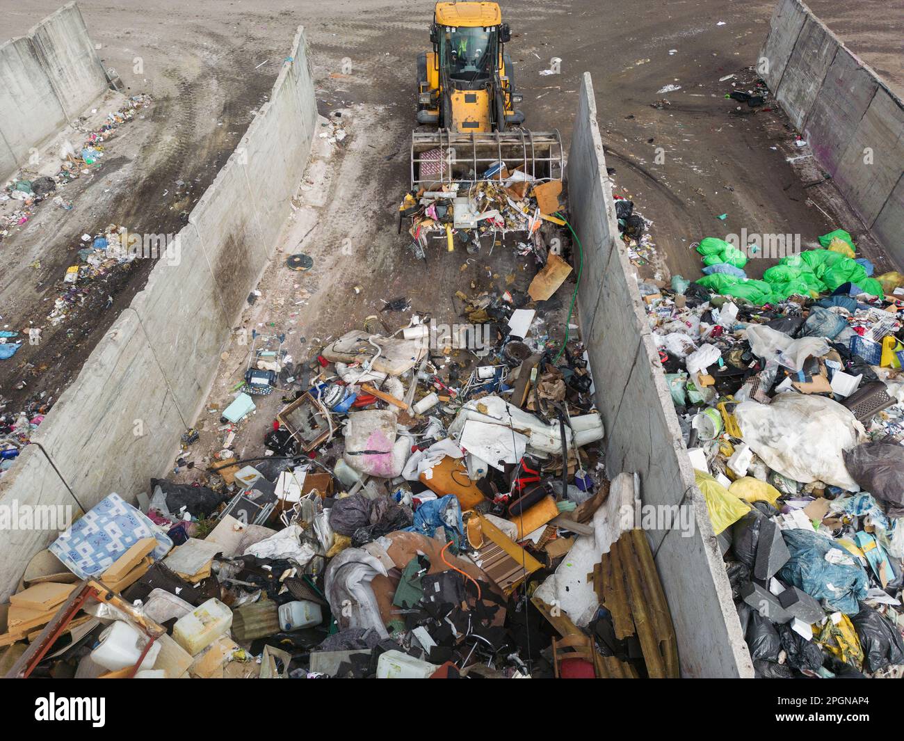 Wheeled loader loading bucket with garbage material and moving it ...