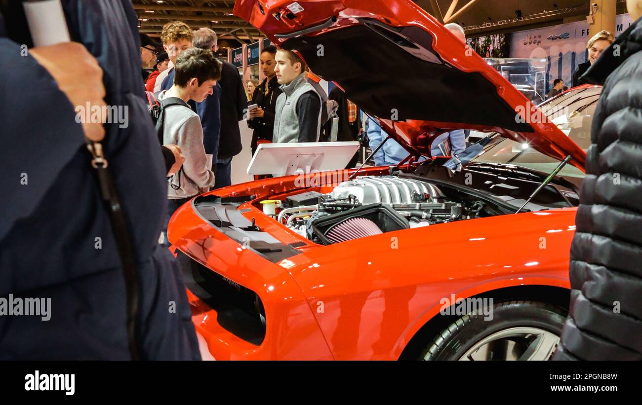 Close view of motor of red Jeep car on display. Crowds looking at new ...