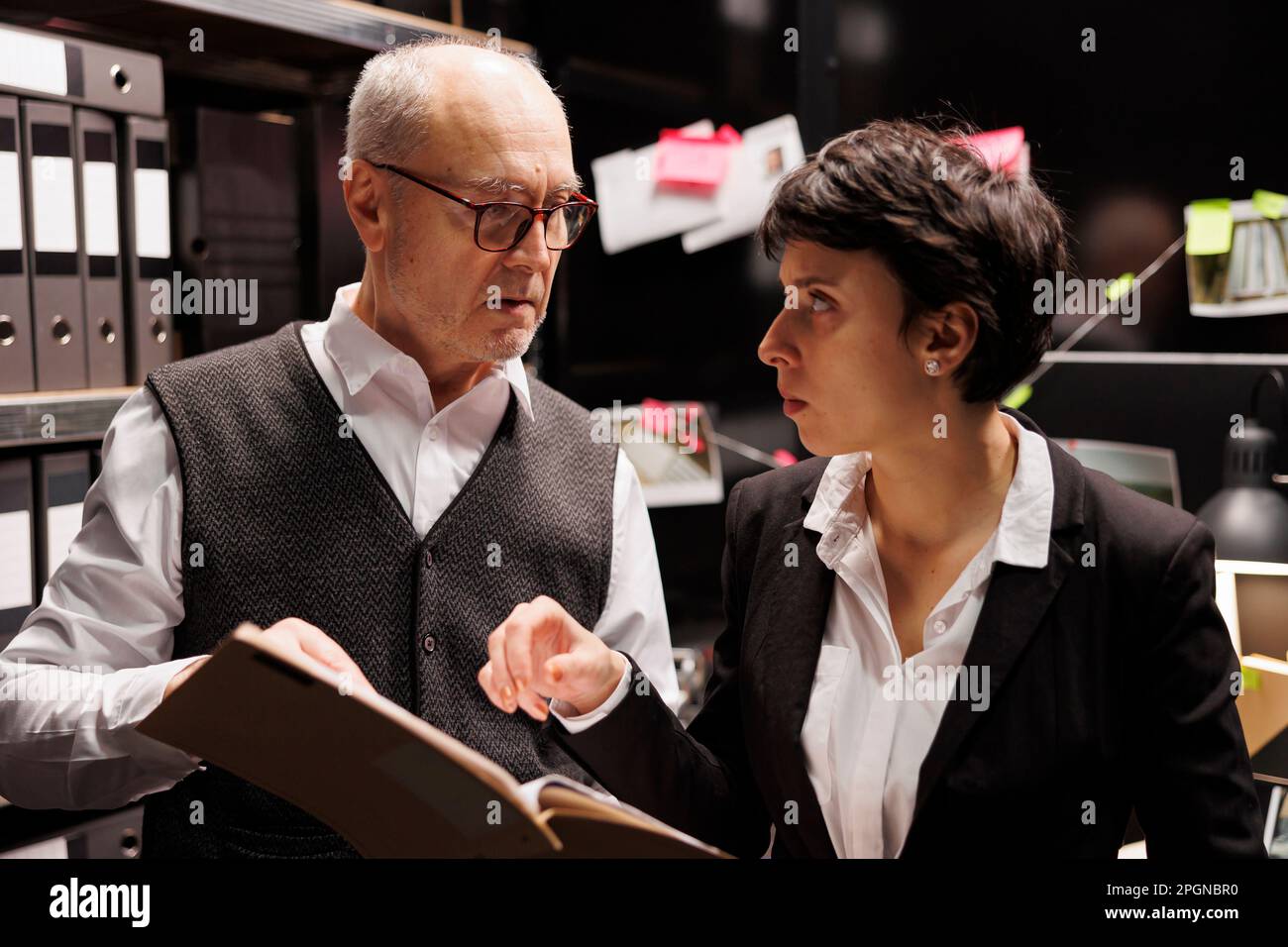 Old private investigator working overhours at criminal case with police ...