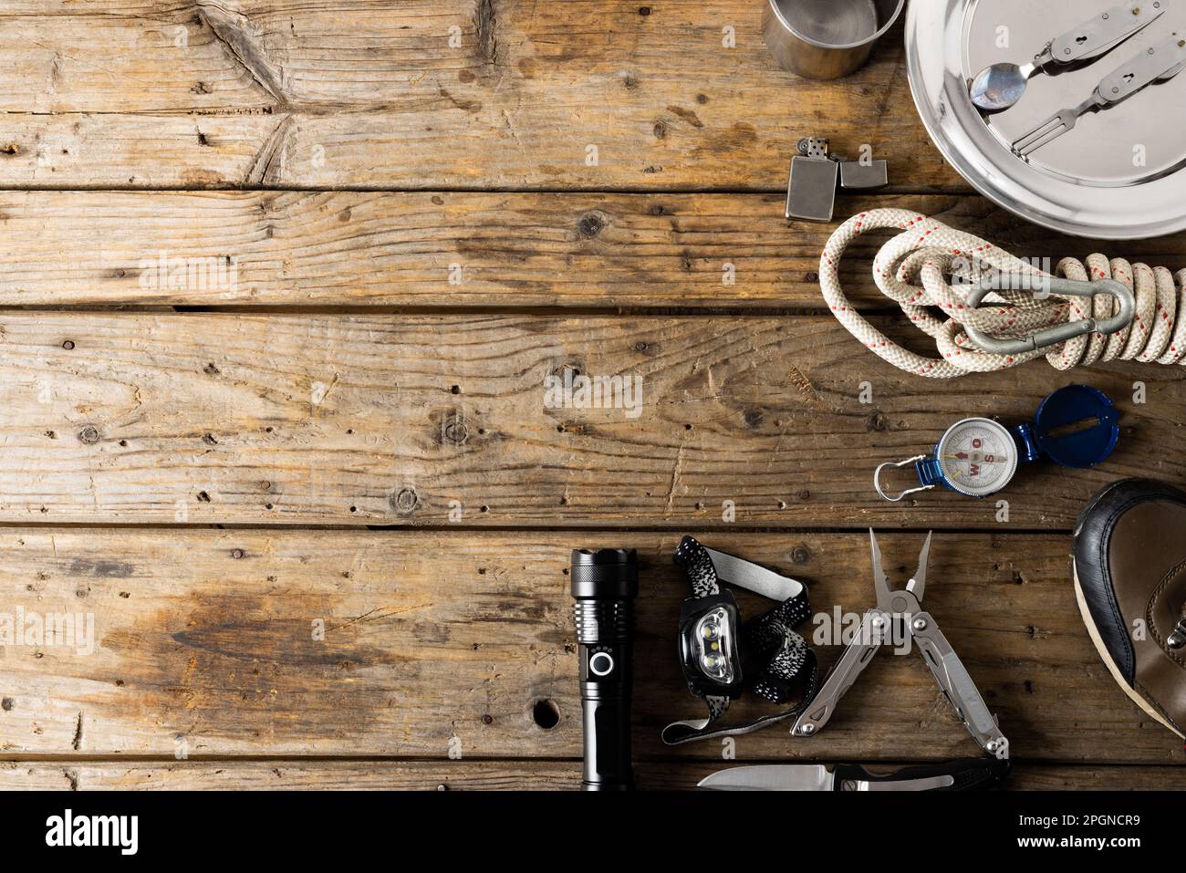 Camping equipment of tools, rope and torch on wooden background with ...